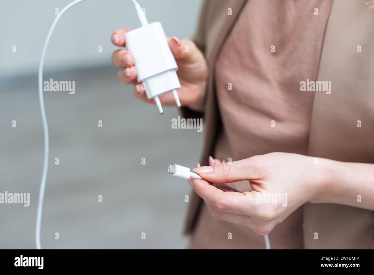 woman holding Electrical adapter. hand holding charger Stock Photo - Alamy