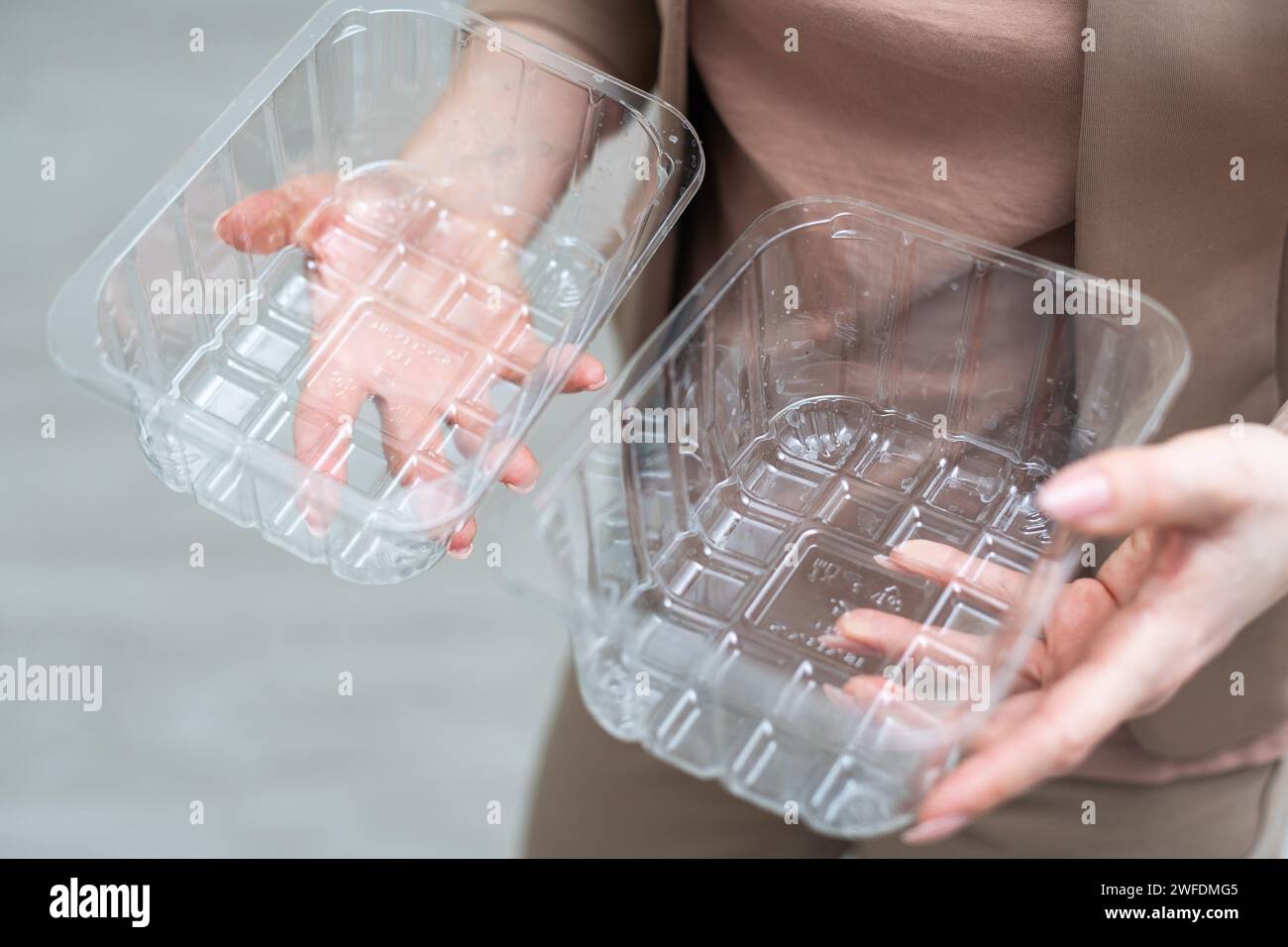 Close up hand holding empty plastic containers on white background. hand throwing empty plastic ...