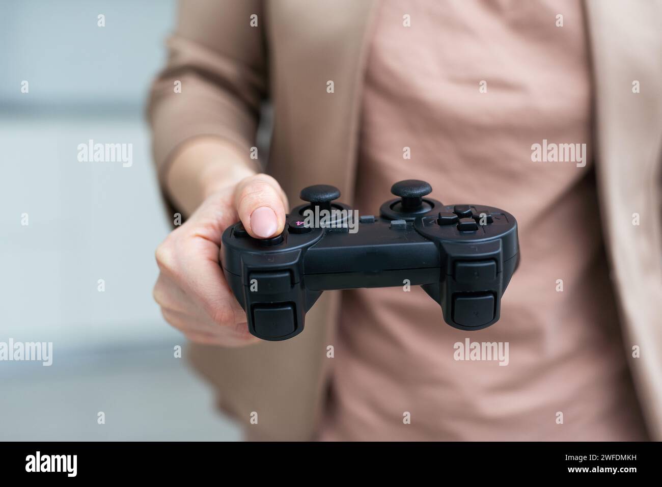 Womans hand playing video game against white background Stock Photo - Alamy