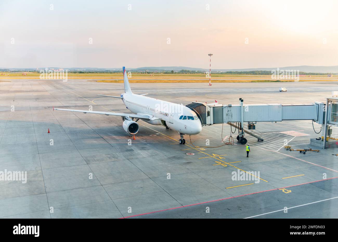 Passenger plane on the airfield connected to walkway.The gate sleeve is ...