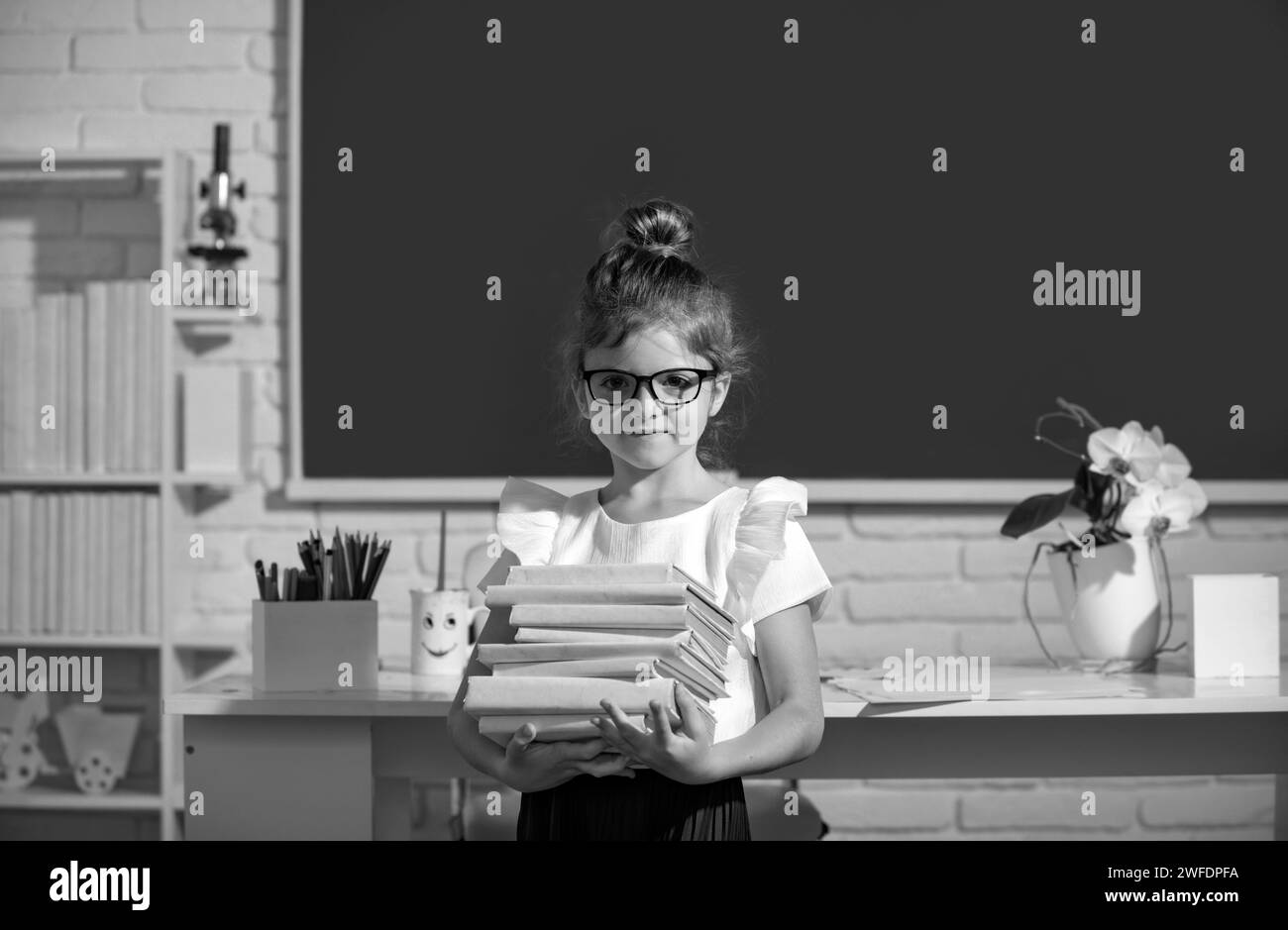 Cute child at school. Kid is learning in class on background of ...