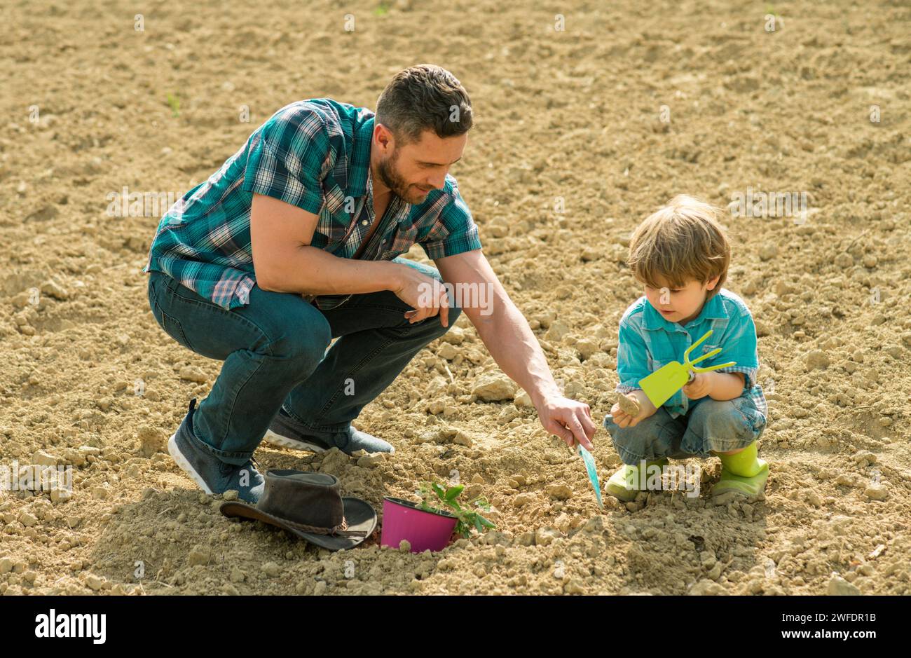 Father and son planting. Growing plants. Spring garden. Dad teaching ...