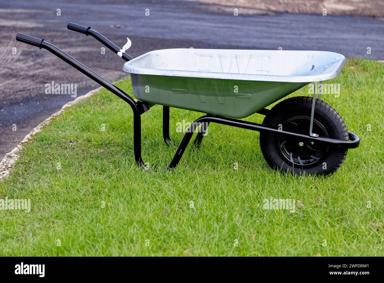 Green wheelbarrow in a garden - wheelbarrow on green grass Stock Photo ...