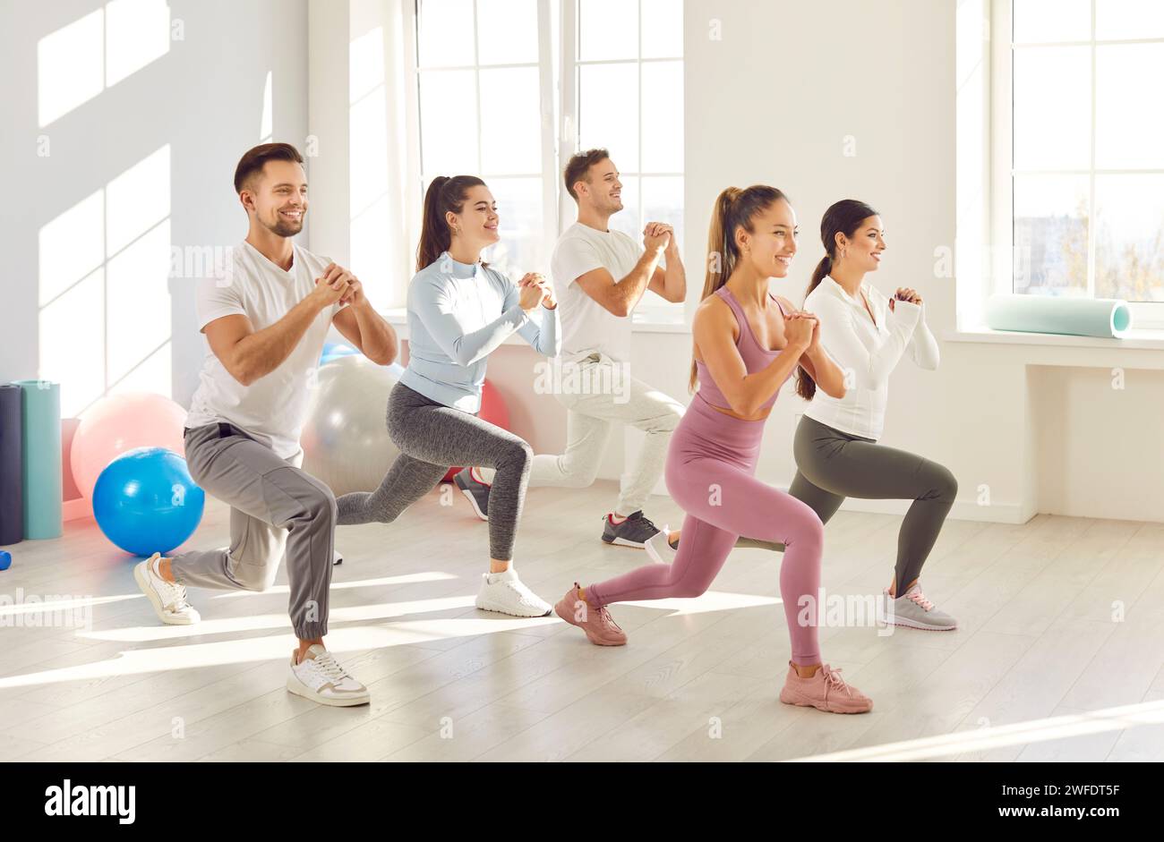 Team Of Athletes Doing Squats In The Gym Stock Photo - Alamy