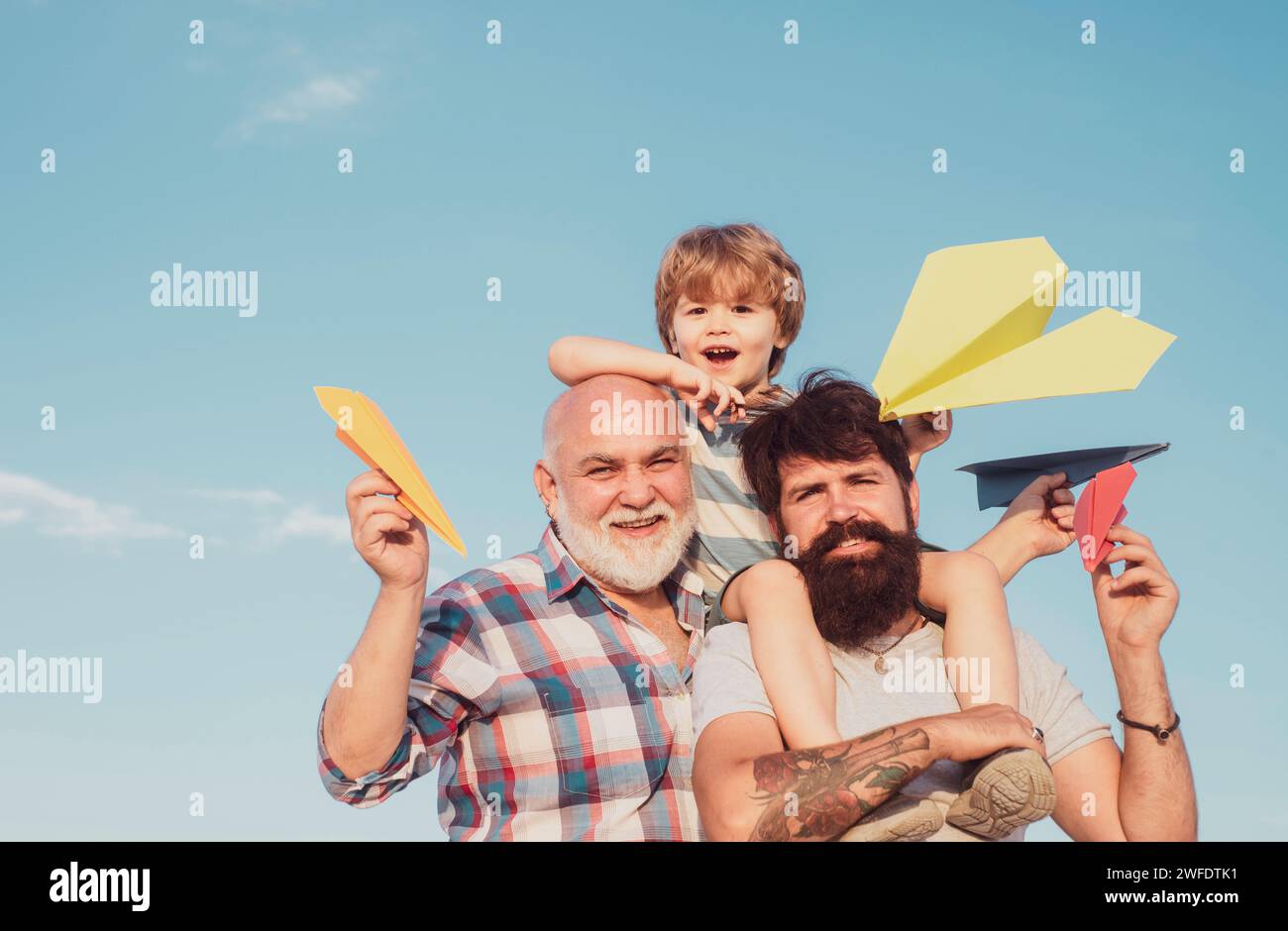 Portrait of happy father giving son piggyback ride on his shoulders and ...