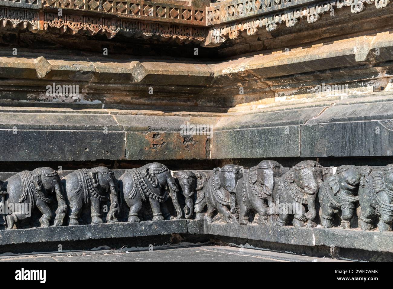 Intricate carvings of a line of elephants on the wall of the ancient ...