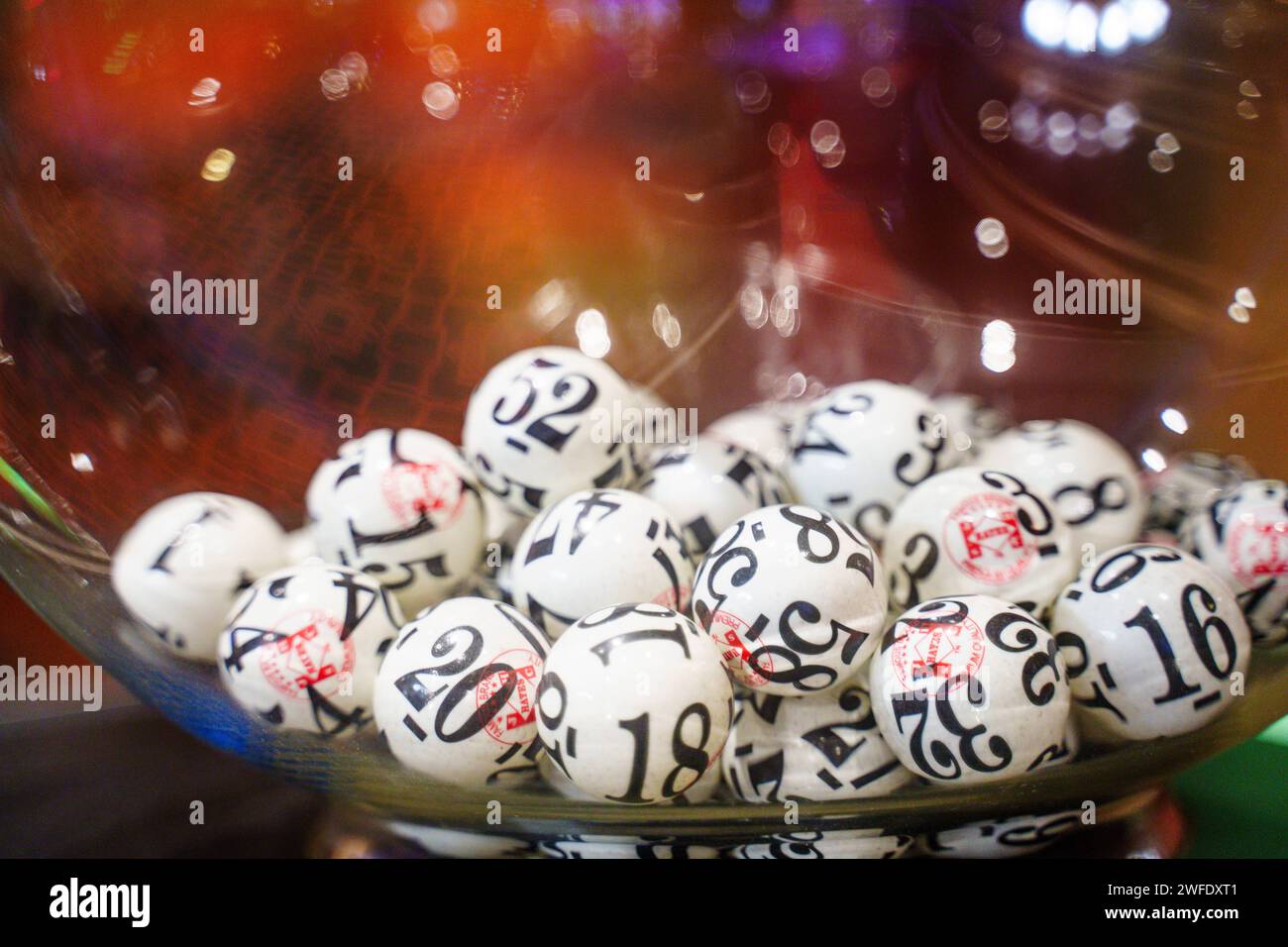 July 20, 2023: White bingo balls with black numbers in a large glass ...