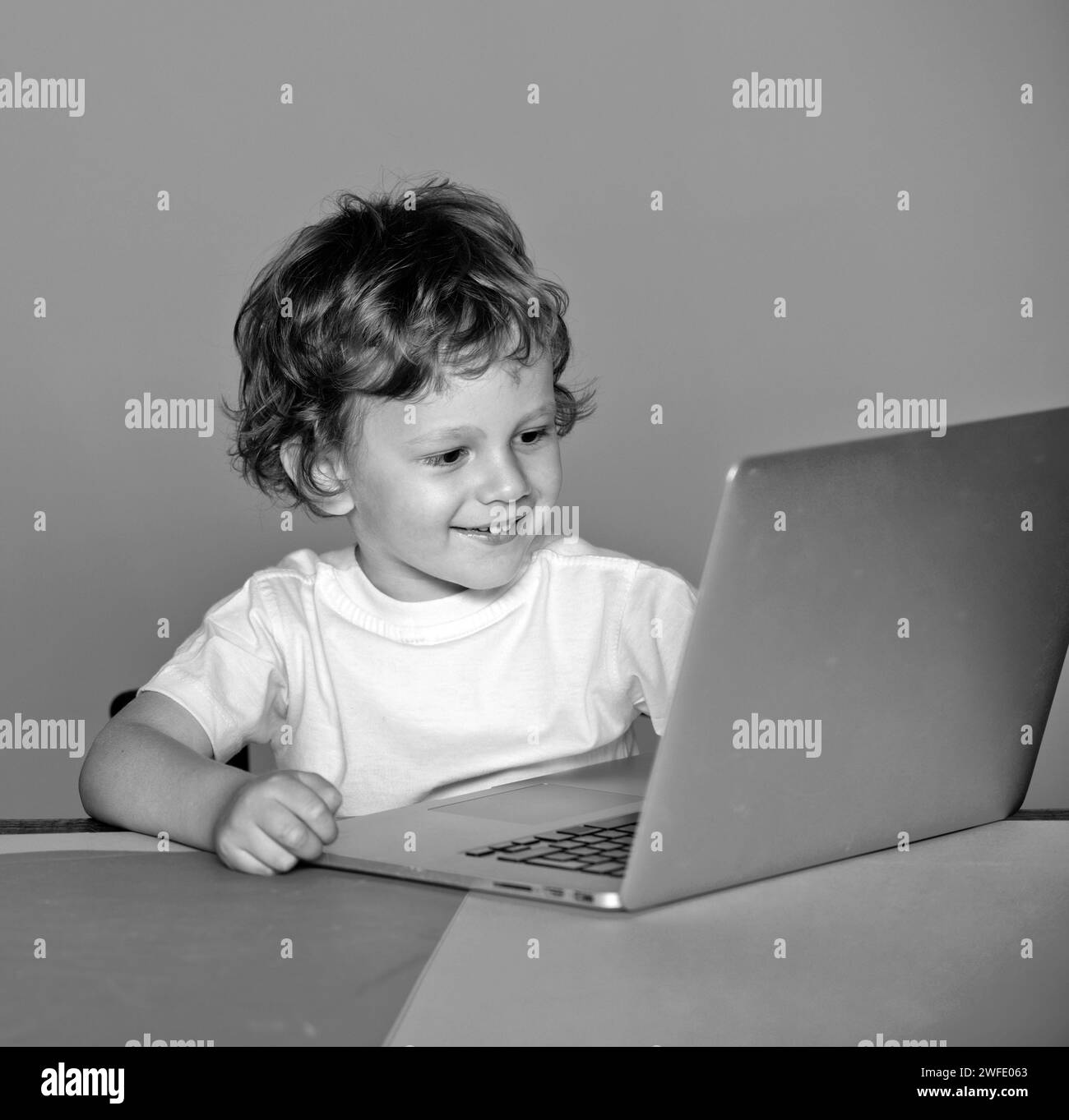 Little boy pupil with happy face expression near laptop, school concept ...