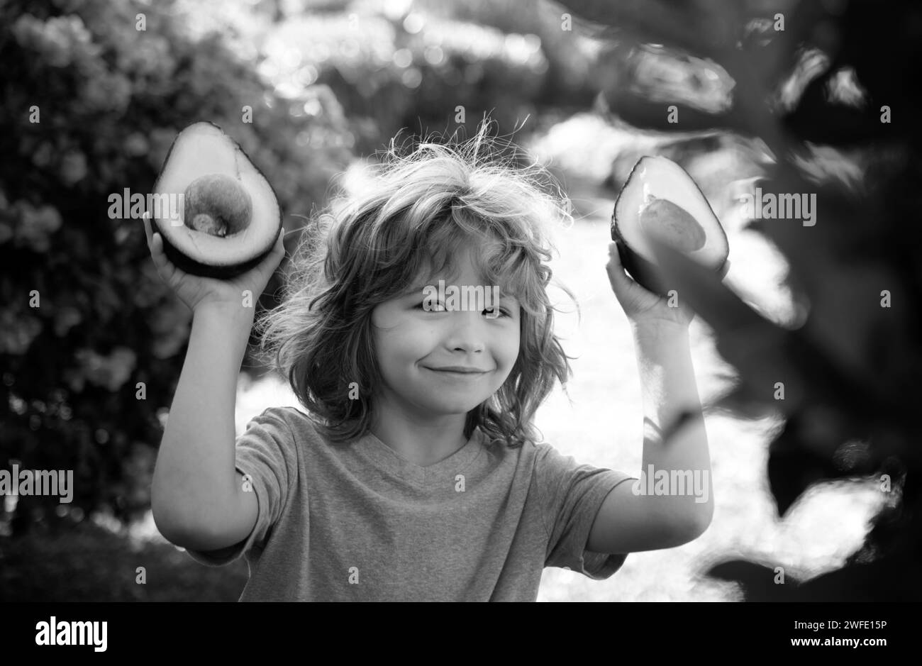 Kid eating and enjoying an avocado on a nature background. Healthy food ...