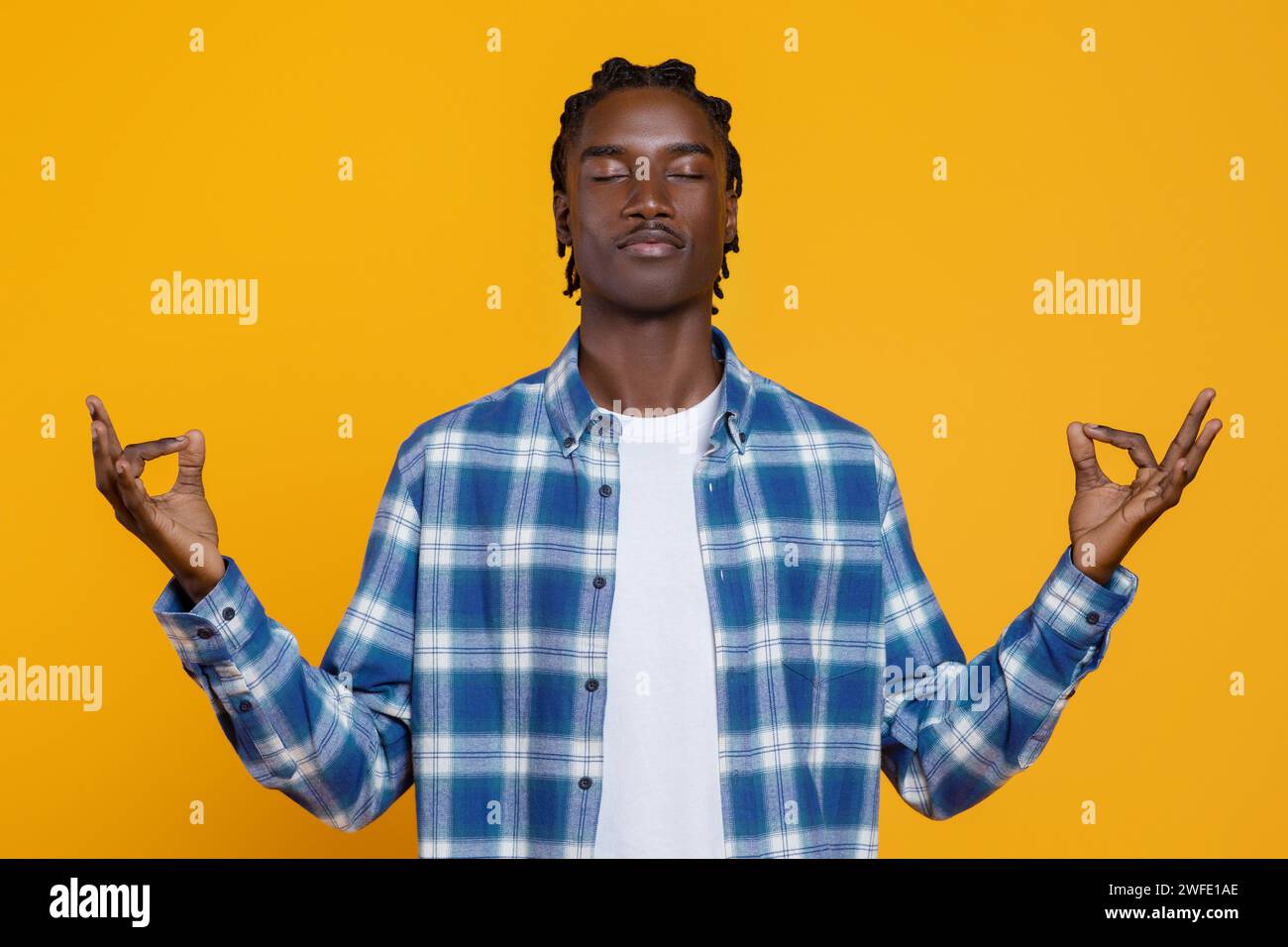 Young black man meditating in zen pose with serene face expression ...
