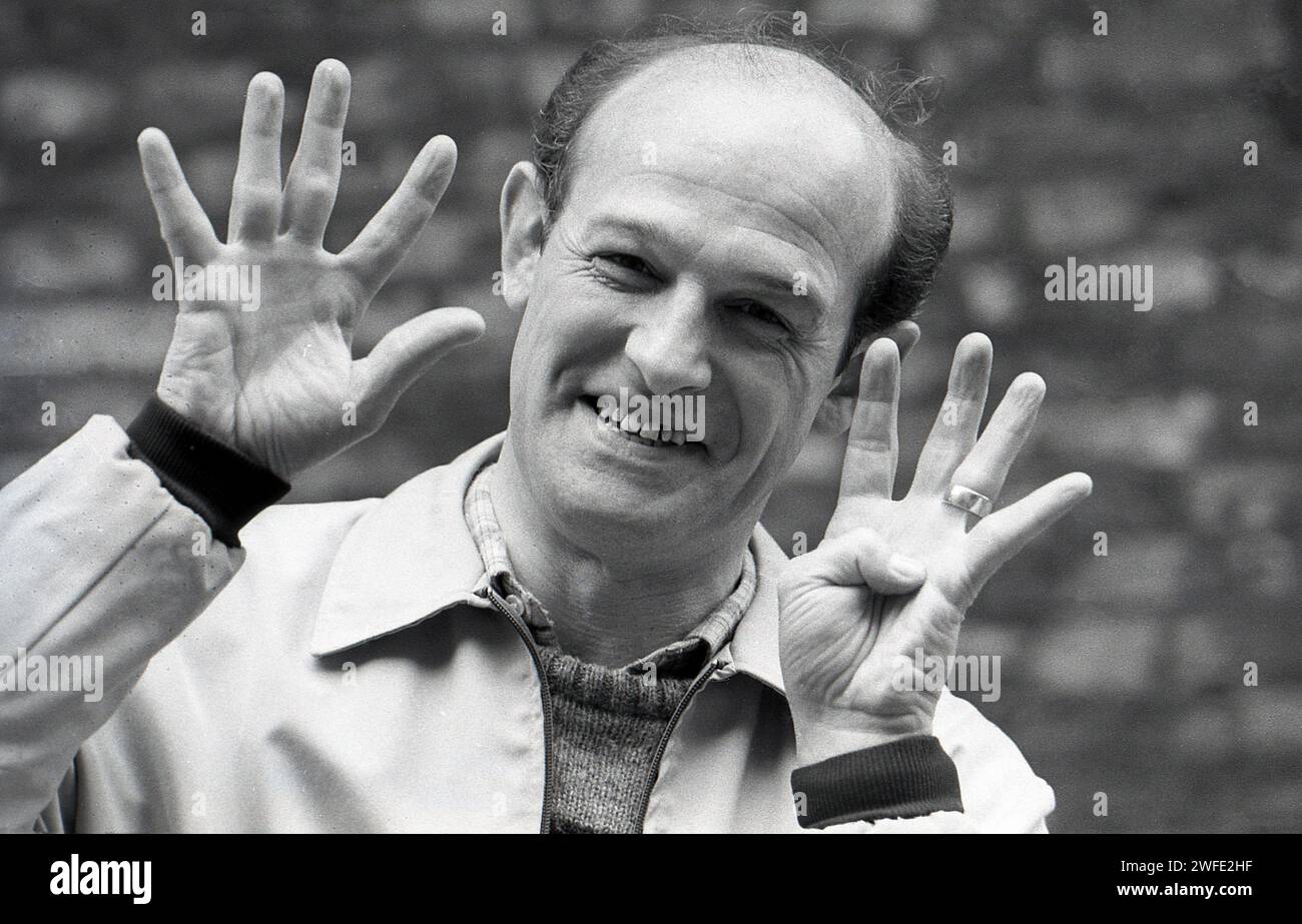 1980s, a male bowls player holding up his hands, fingers and folded ...