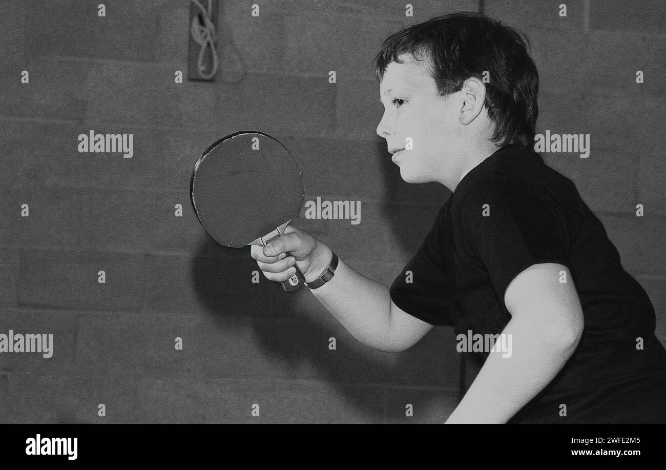 1987, inside a sports centre, a young boy playing table tennis or ping ...