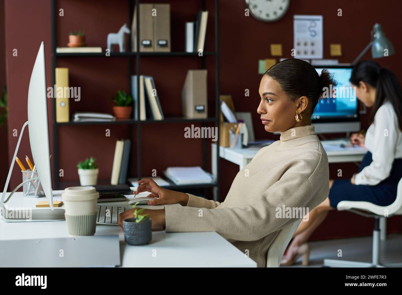 Side view of young bored African American businesswoman scrolling ...