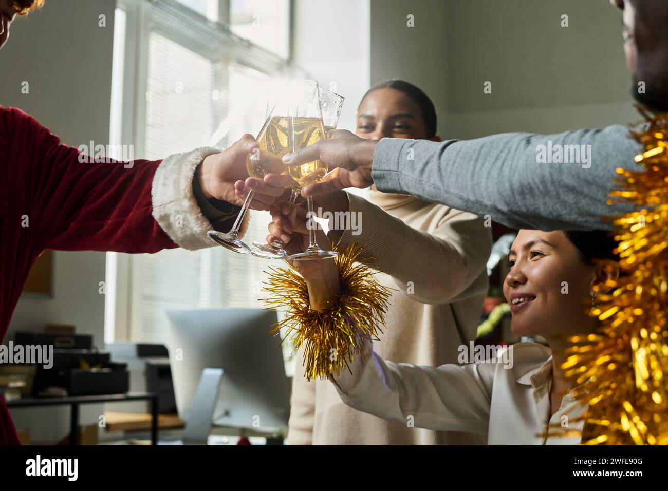 Group of happy young intercultural managers toasting with sparkling ...