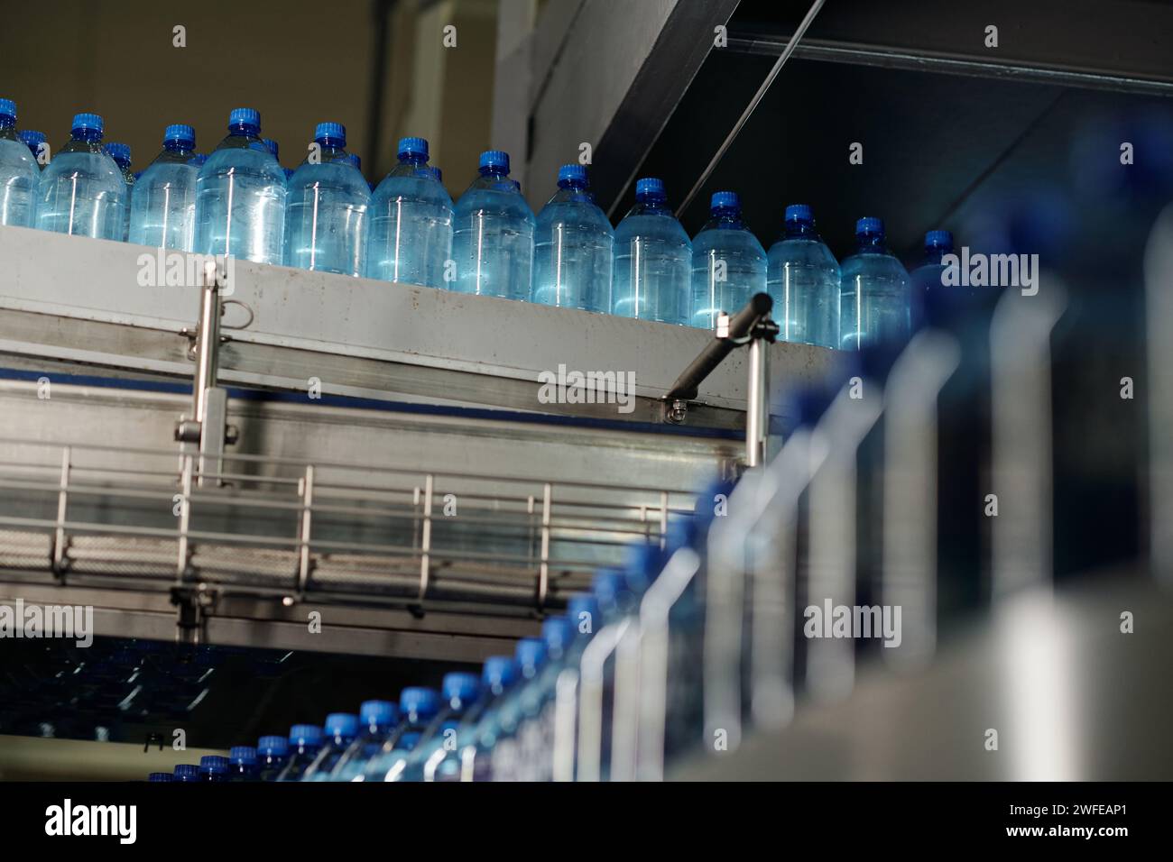Row of capped plastic bottles with still and carbonated mineral water ...