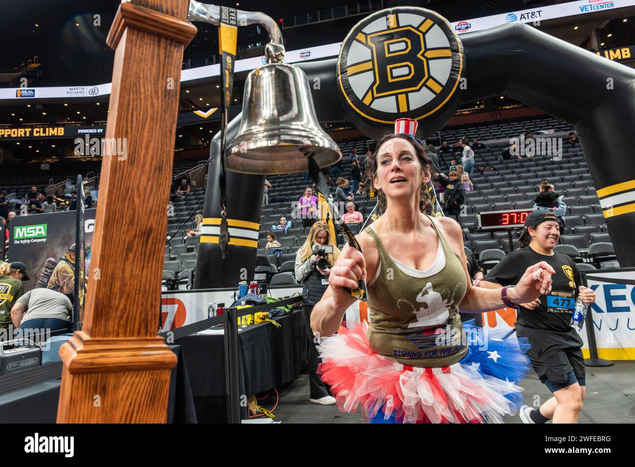 Woman in tutu ringing bell at the finish line of the 8th annual BFit ...
