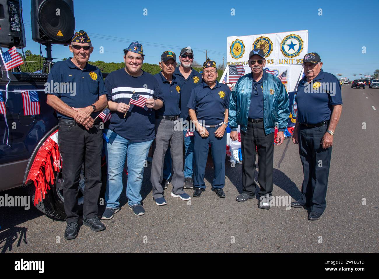 Group of senior male veterans stand in front of float for American ...