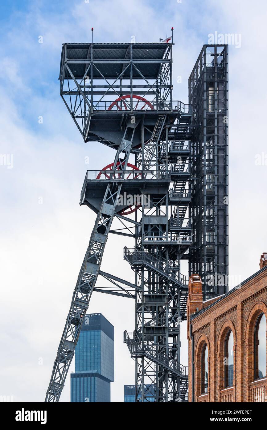 A mine hoist shaft against a cloudy sky. Modern office skyscrapers in ...