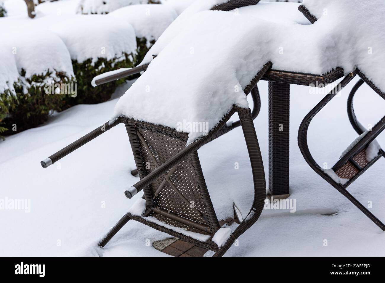 Plastic chairs and a garden table covered with a thick layer of snow ...