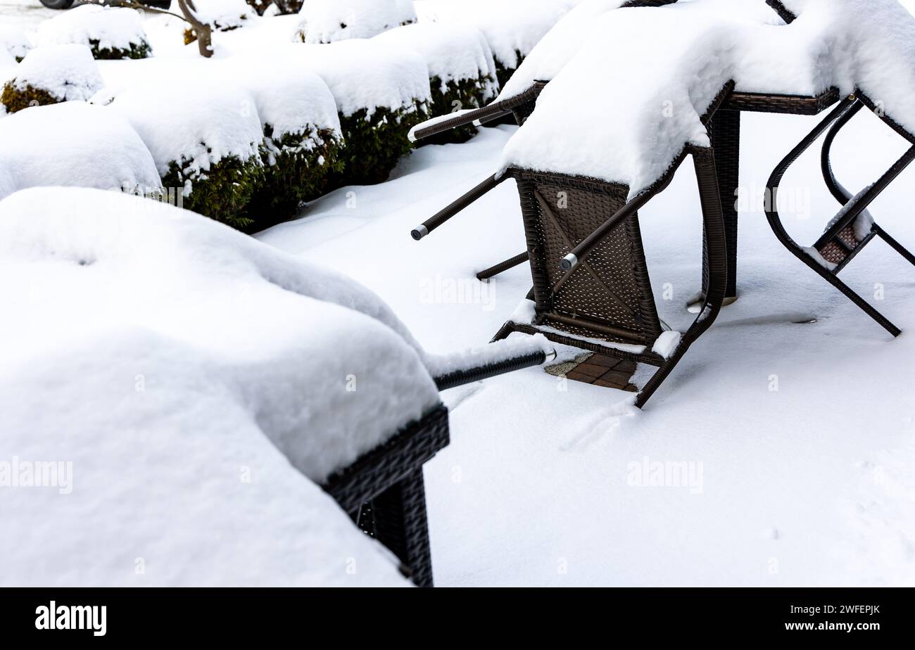 Plastic chairs and a garden table covered with a thick layer of snow ...