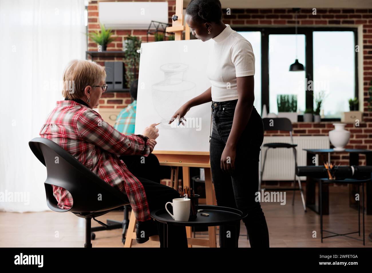 Senior woman learning to draw with teacher, taking art class, learning ...