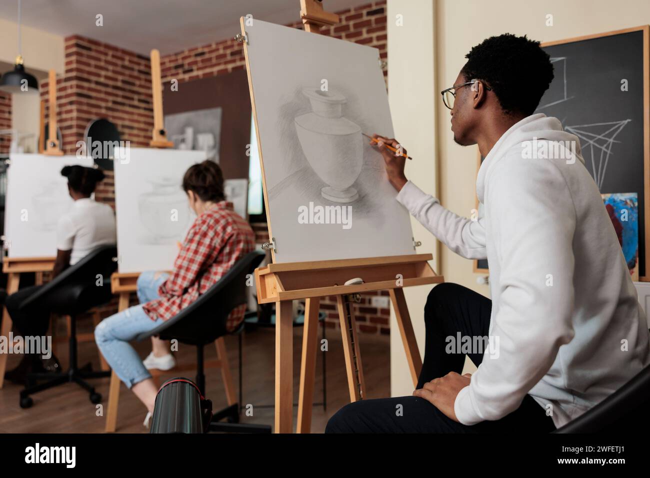 Diverse people engaged in arts activities. Young African American guy ...