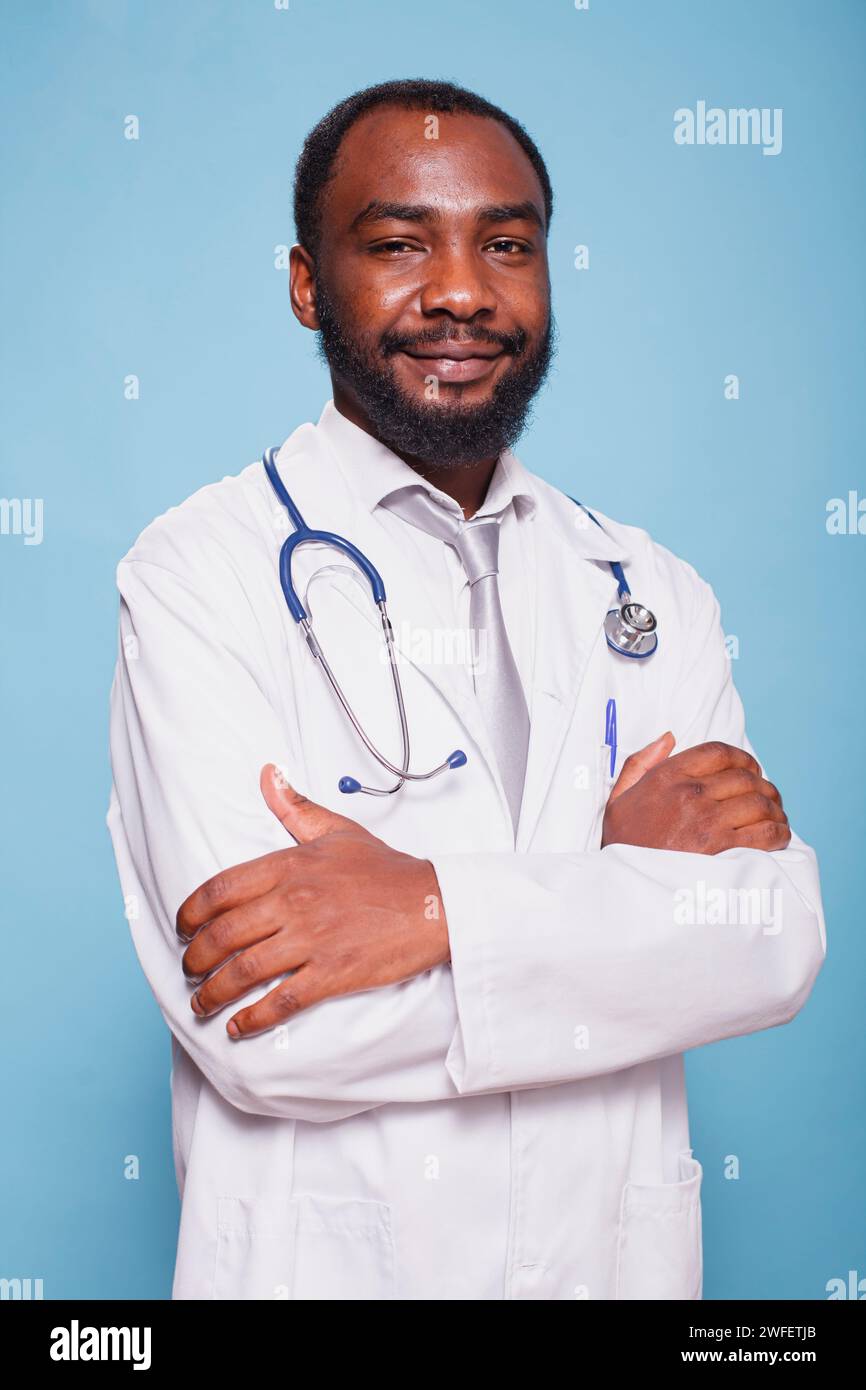 Smiling doctor of african american ethnicity having his arms crossed is ...