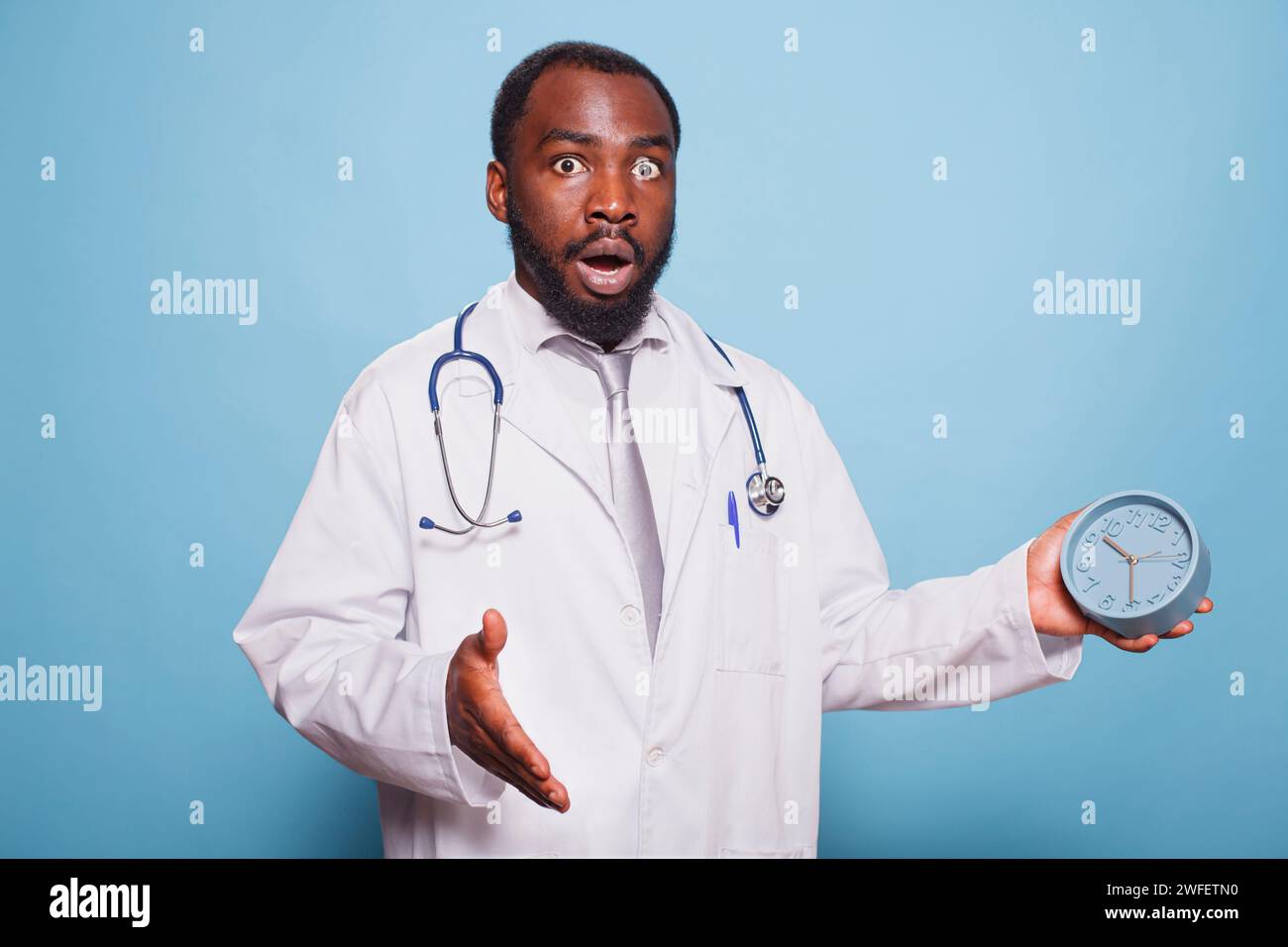 Medical practitioner looking surprised running out of time holding ...