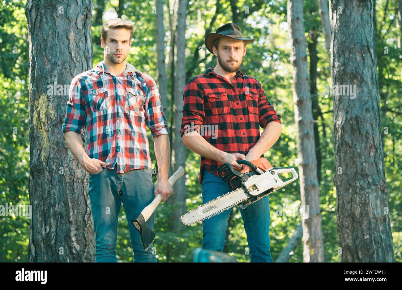 Two ypung Lumberjack man holds axe. Brutal lumberjack concept Stock ...