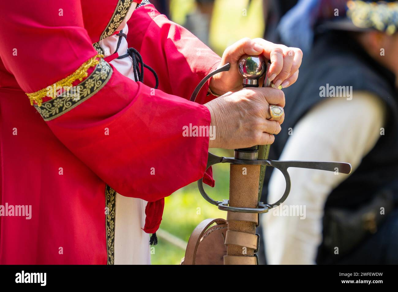 A woman in red with a medieval sword in her hand Stock Photo - Alamy