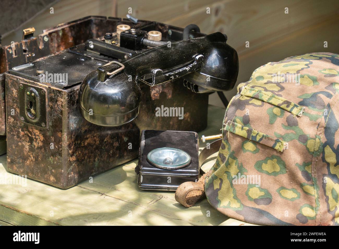 Old WWII military phone with flashlight and camouflage military helmet ...