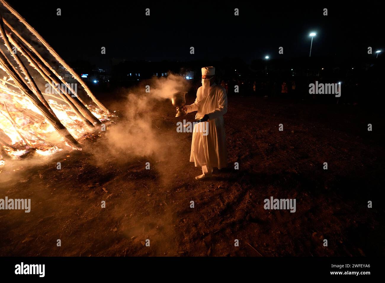 An Iranian Zoroastrian priest walks near a giant bonfire in a ceremony ...