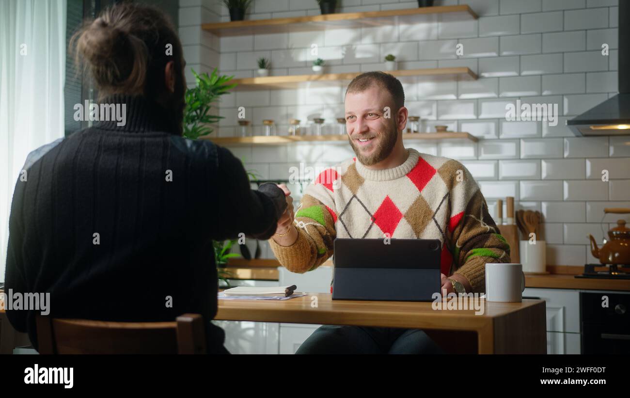 Two co-worker are sitting in office kitchen working with tablet ...