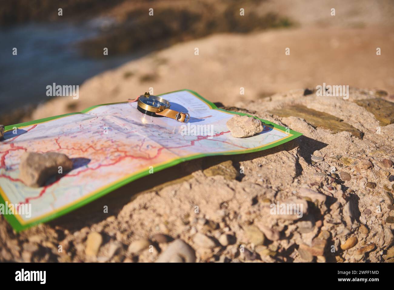 A geographic map and nautical equipment, a compass on the rock against ...