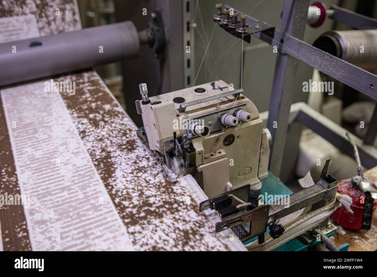 Overlocking the carpet edge in the carpet weaving factory. Factory ...
