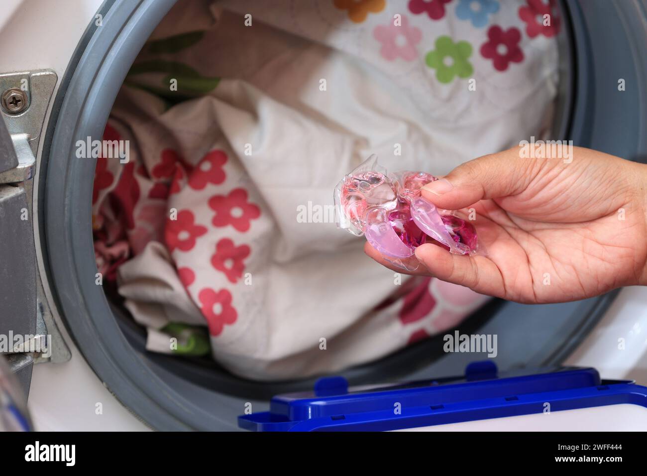 Woman Putting Laundry Pot to Electric Washing Machine. Household ...