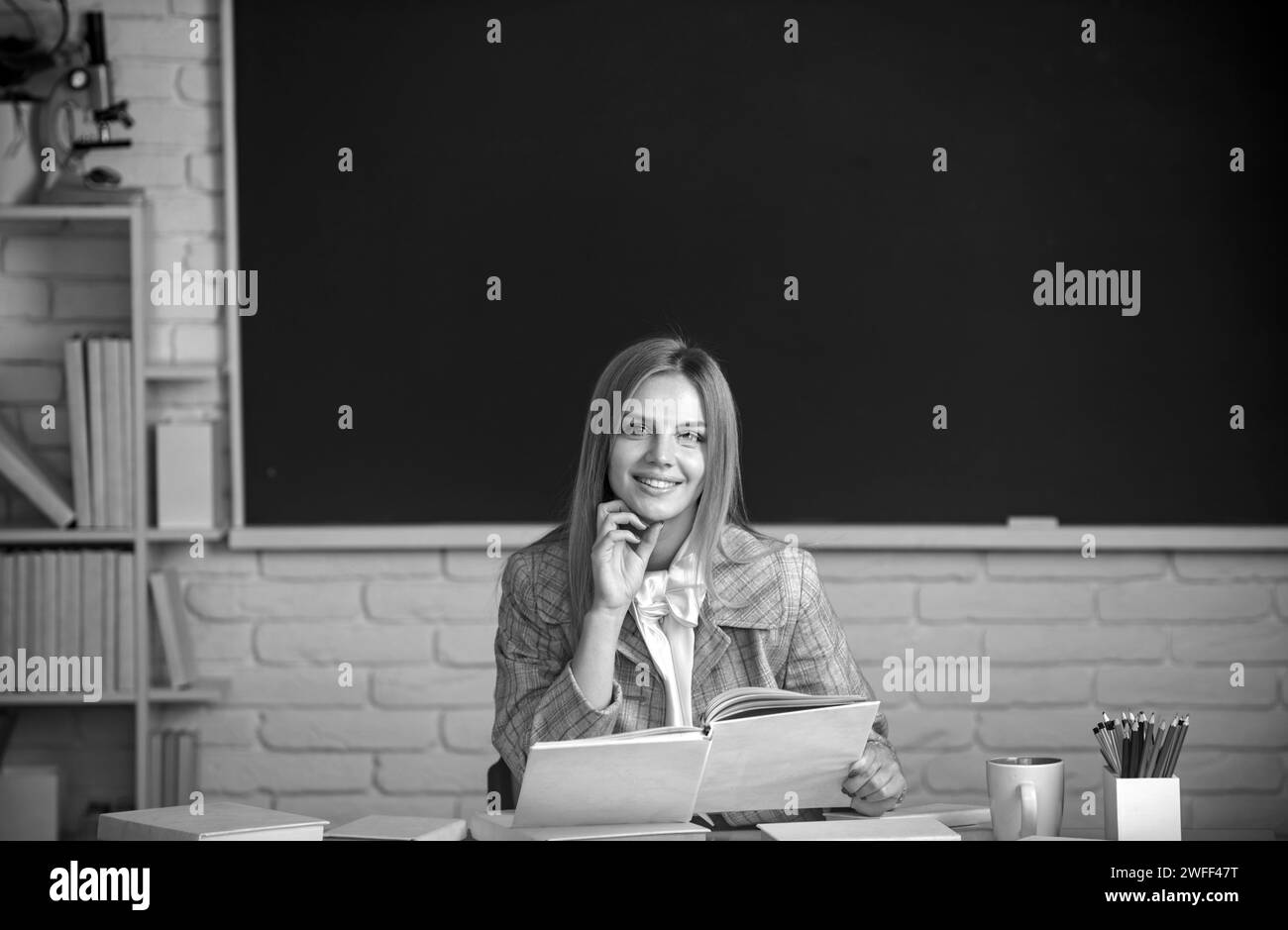 Portrait of smiling young college student studying in classroom. Happy ...
