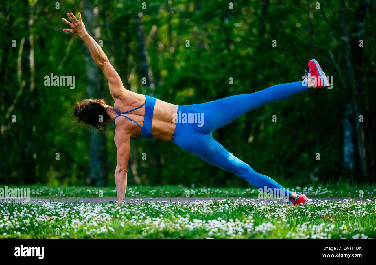 Female athlete working out wearing sportswear among cherry trees Stock ...
