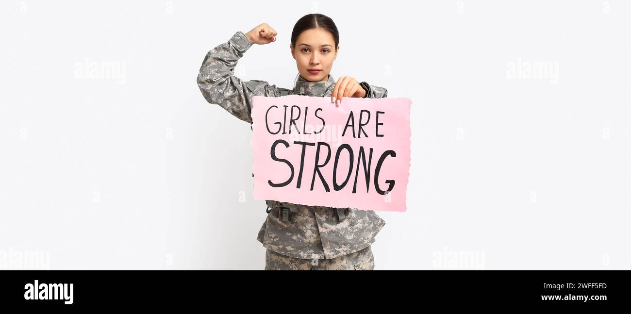 Young female soldier holding poster with slogan GIRLS ARE STRONG on ...