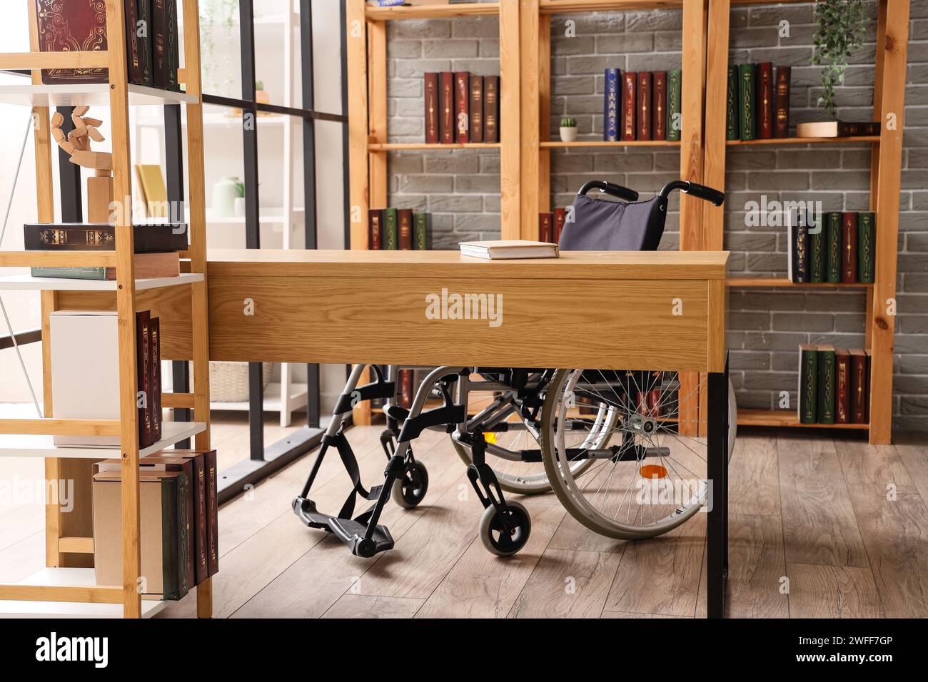 Wheelchair at table in library Stock Photo - Alamy