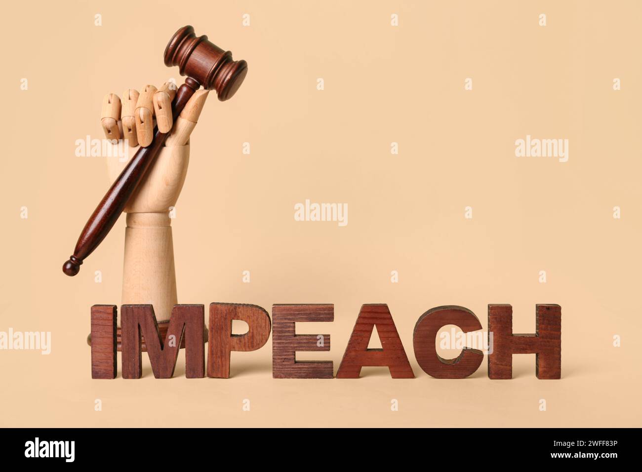 Wooden hand with judge gavel and word IMPEACH on beige background Stock ...
