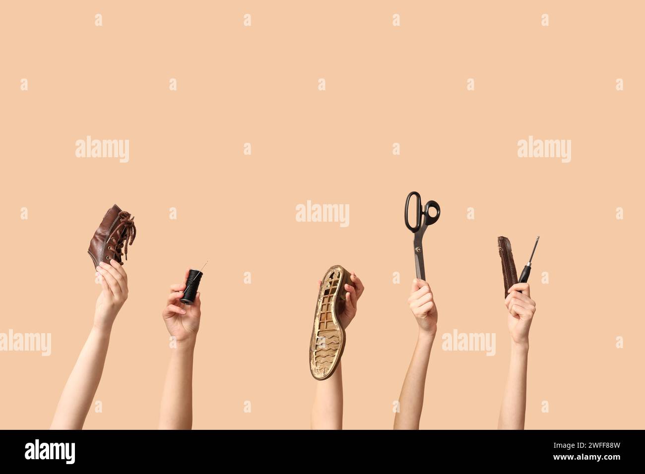 Female hands with shoes pieces, scissors and sewing thread on beige ...