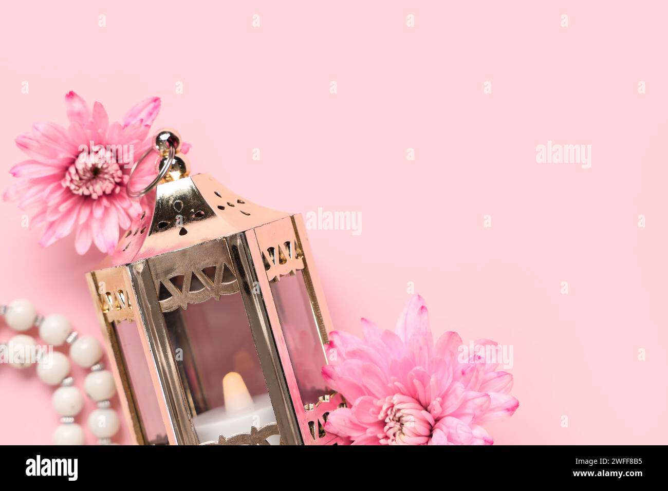 Muslim lamp with flowers and tasbih on pink background. Ramadan ...