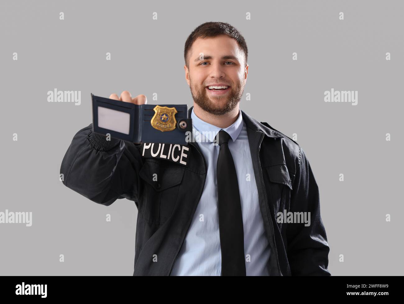 Male police officer with identification badge on grey background Stock ...