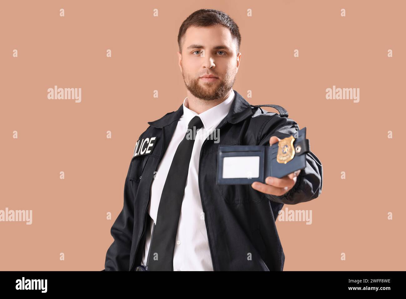 Male police officer with identification badge on beige background Stock ...