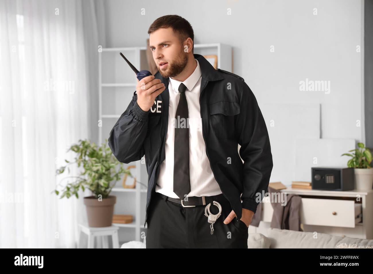 Male police officer with radio transmitter indoors Stock Photo - Alamy