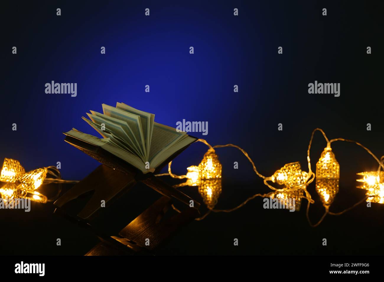Rehal with Koran and garland for Ramadan on dark blue background Stock ...