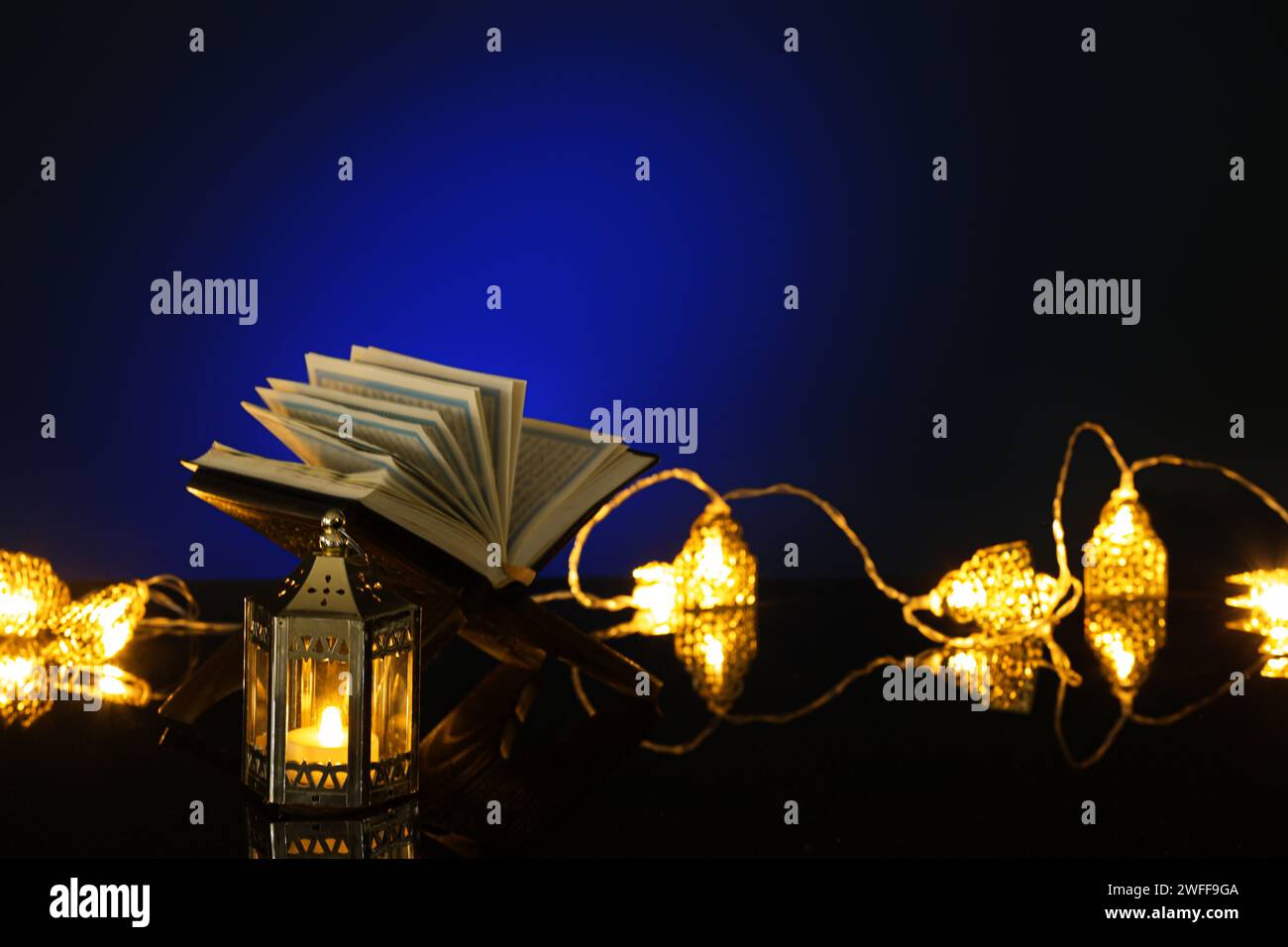 Rehal with Koran and garland for Ramadan on dark blue background Stock ...
