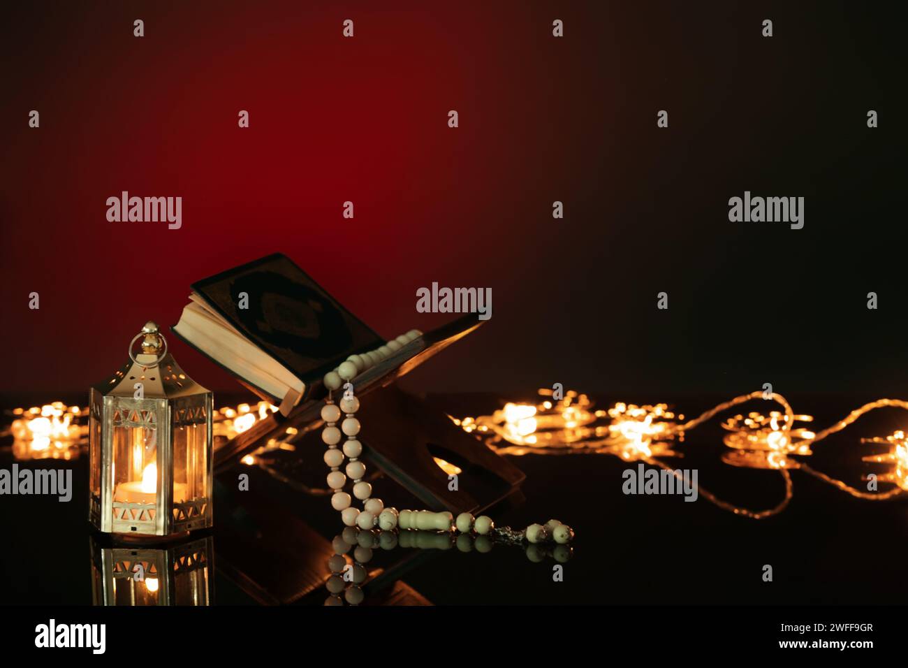 Rehal with Koran, Muslim lamp and garland for Ramadan on dark red ...