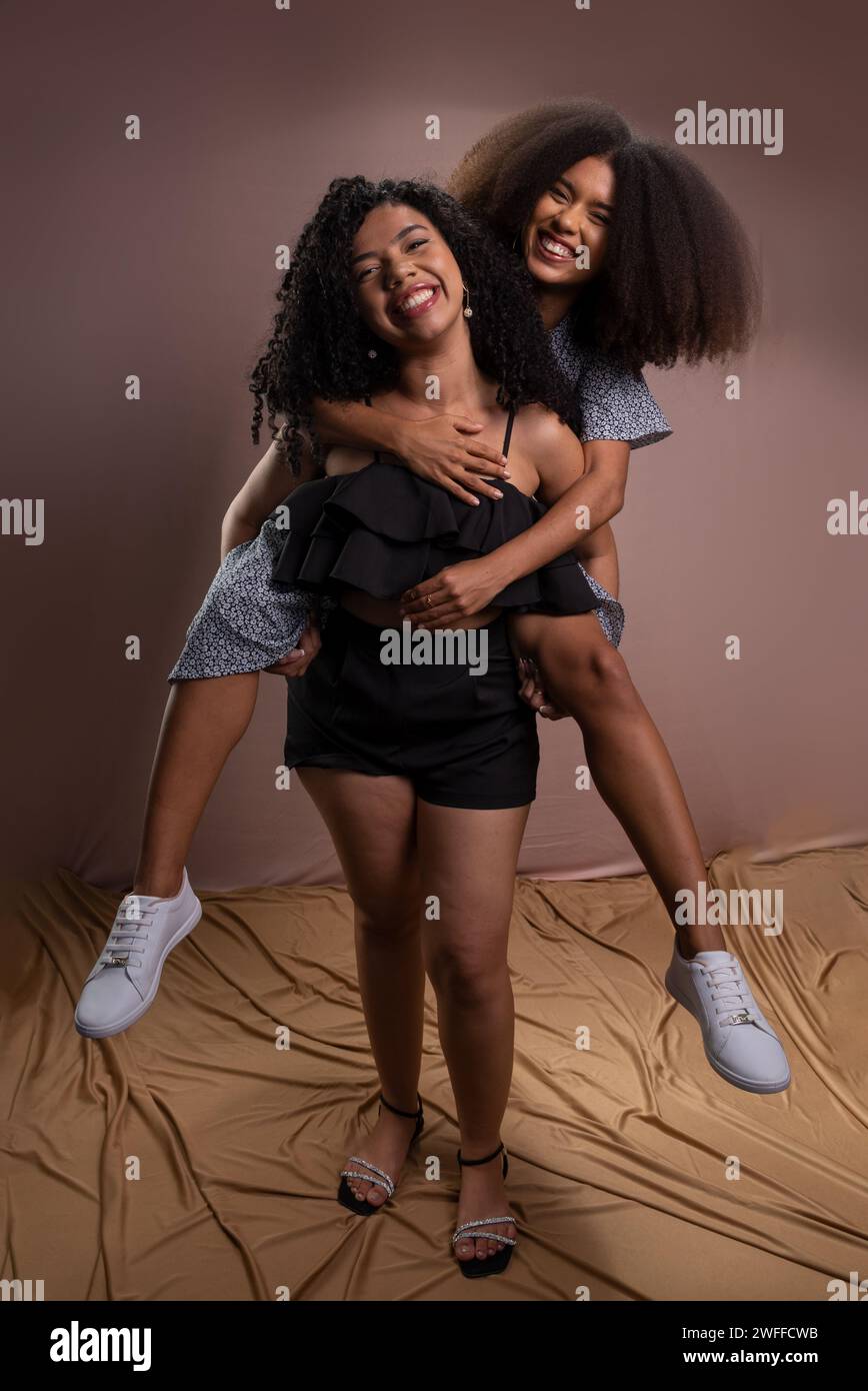 Two young, happy, beautiful friends. One carries the other on its back ...